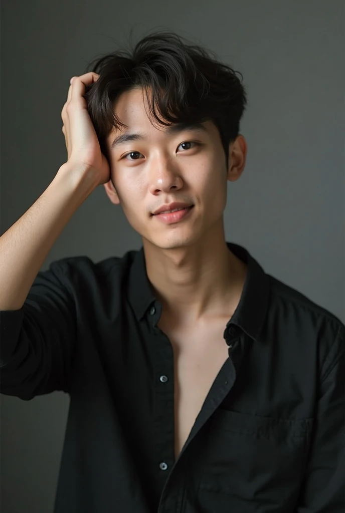 A young Asian man, positioned slightly off-center to the left of the ...