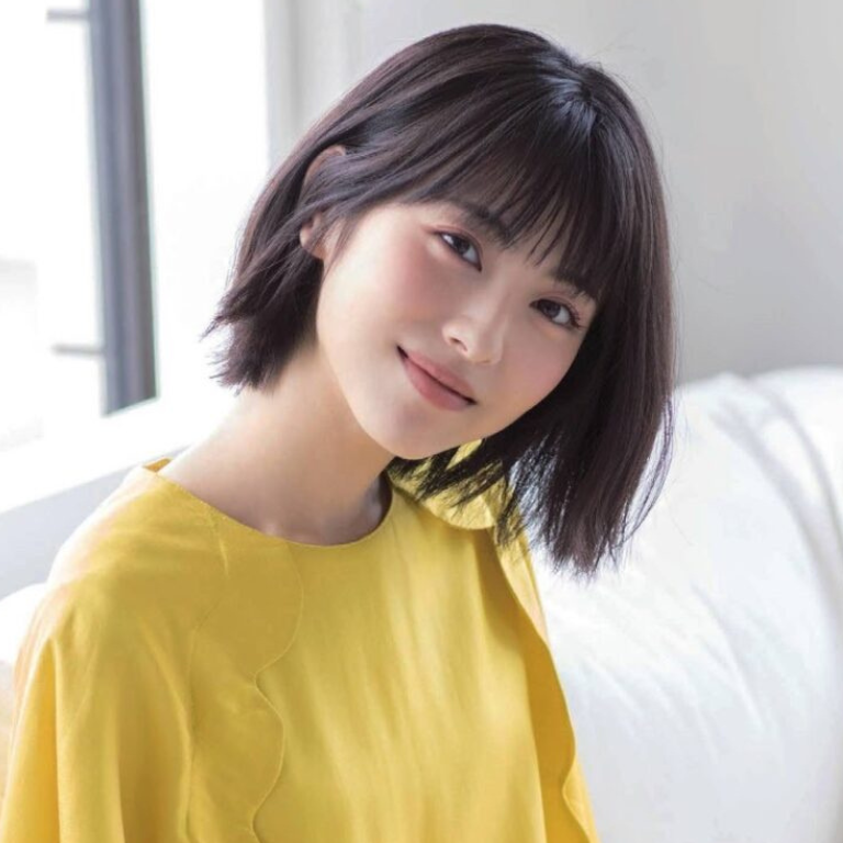 A close up of a woman in a yellow shirt sitting on a couch - SeaArt AI